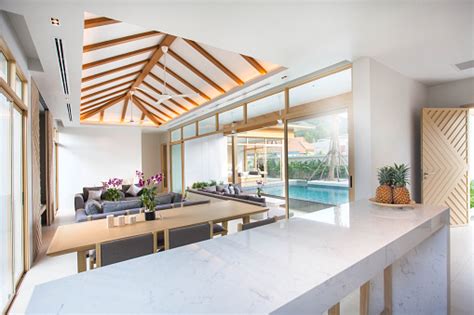 럭셔리 풀 빌라의 거실의 인테리어 디자인 높은 제기 천장과 나무 식탁 공기와 밝은 공간 0명에 대한 스톡 사진 및 기타 이미지