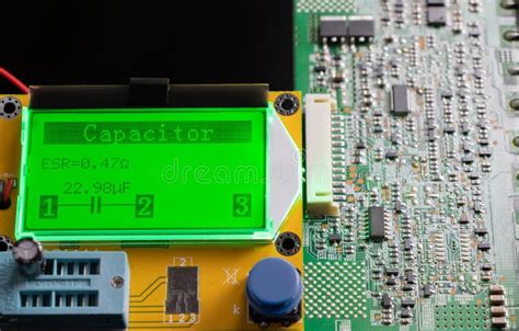 Measuring The Capacitance Of An Electrolytic Capacitor Microcircuit On A Black Background Stock