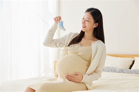 아기 양말을 들고 임신한 어머니 사진 무료 다운로드 Lovepik