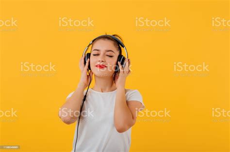 행복한 십대는 눈을 감고 흰색 셔츠를 입고 노란색 배경에 고립 된 긍정적 인 얼굴 감정으로 헤드폰에서 음악을 듣고 귀여운에 대한 스톡 사진 및 기타 이미지 Istock