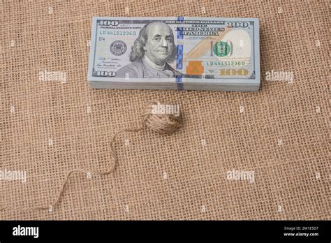 Spool Of Linen Spool Is Placed On Bundle Of Us Dollar Banknotes Stock
