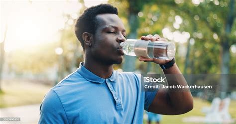 피트니스 운동 및 운동 휴식 수분 공급 및 달리기로 인한 갈증을 위해 공원에서 물을 마시는 흑인 디톡스 러너 및 리프레시 유산소 회복 및 자연 속에서의 훈련을 위한 액체 병