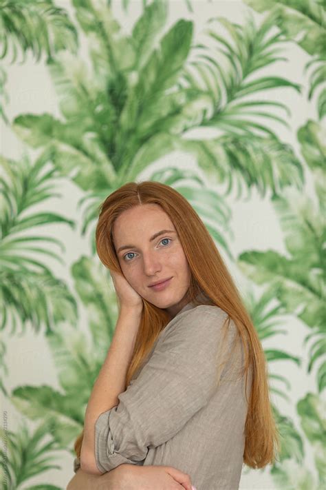 Portrait Of A Redhead Woman With A Floral Background By Stocksy