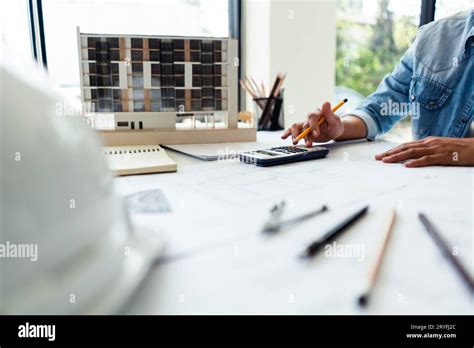 Engineer Woman Use Scientific Calculator And Working To Drawing Construction On Blueprint In