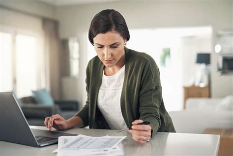 디지털 은행 앱에 대한 온라인 뱅킹 청구서 또는 소득 투자를위한 노트북 및 서류 작업이있는 예산 금융 및 저축 여성 모기지 금융 서류 또는 종이로 세금 관리를 하는 여성