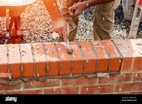 Close Up Of A Brick Wall And Jointer Trowel Used By The Worker To Apply