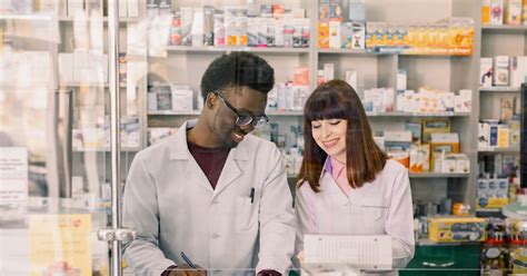 약국에서 자신감 있는 다민족 남성 및 여성 약사 아프리카계 미국인 남성 약사가 약국에서 재고를 작성하는 동안 클립보드에 메모를 하고 있습니다 사진 Unsplash의