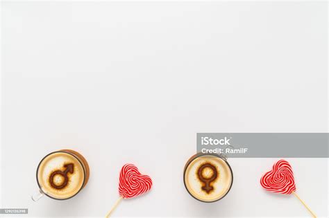 휘핑 우유 거품에 금성과 화성의 상징과 커피 두 컵과 흰색 탁상에 심장 모양의 커플 롤리팝 발렌타인 데이에 로맨틱 한 달콤한