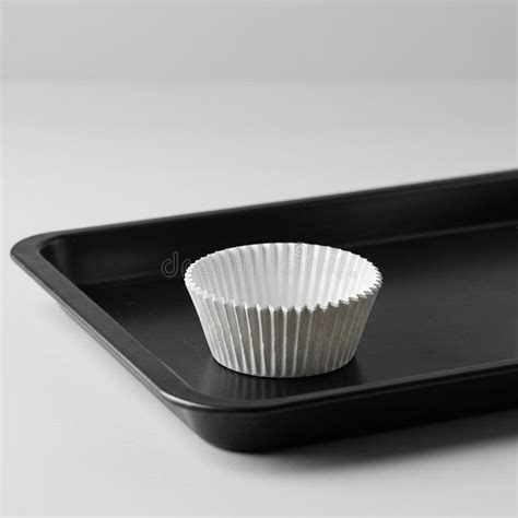 White Paper Cupcake Liner Placed In A Black Baking Tray The Liner Has