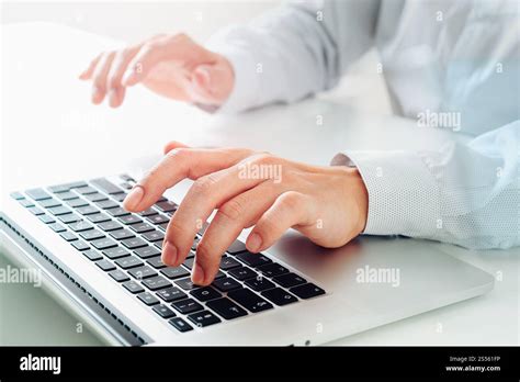 Close Up Of Businessman Typing Keyboard With Laptop Computer On White Desk In Modern Office