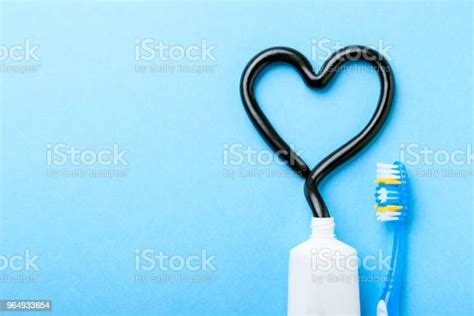 하얀 치아에 대 한 숯에서 검은 치약 심장 관 및 파란색 배경에 칫 솔의 형태로 치아붙여넣기 석탄에 대한 스톡 사진 및 기타