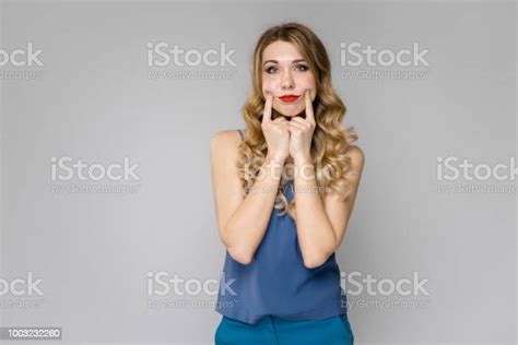 매력적인 금발 슬픈 심각한 소녀 회색 배경에 그녀의 얼굴 가까이 손으로 푸른 옷 간판에 대한 스톡 사진 및 기타 이미지 간판 감정 개념 Istock