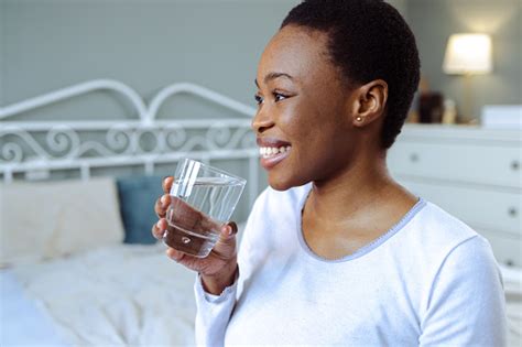 침실에서 유리로 물을 마시는 젊은 아프리카계 미국인 여성 20 24세에 대한 스톡 사진 및 기타 이미지 20 24세 20 29세 가정 생활 Istock