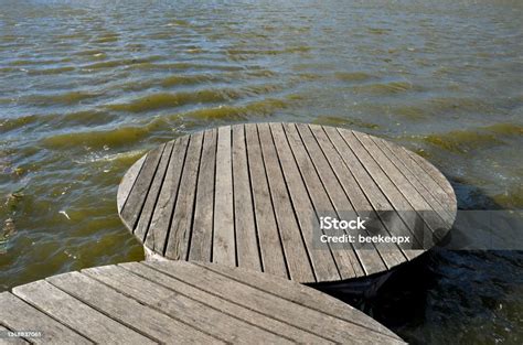 나무 판자로 만든 떠있는 산책로 기둥의 좁은 곡선 길은 호수 물 위 바닥으로 구동된다 난간이 없습니다 개별 원형 보드로 만든 더 많은 디자인 보도 가을 방파제 0명에 대한