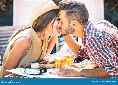 Couple In Love Kissing At Bar Eating Local Food On Travel Excursion