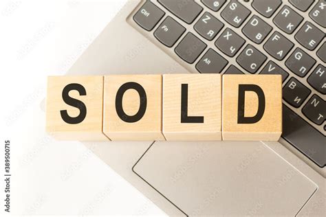 Word Sold Wooden Cubes With Letters Isolated On A Laptop Keyboard Business Concept Image