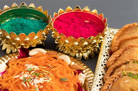 인도 미타이 잘레비 게와르 구지아 또는 구지야와 화려한 굴라 비어 또는 아비르의 상세한 클로즈업은 회색 배경에 행복한 홀리 축하골든 그릇에 제공 가루로 빻은에 대한 스톡