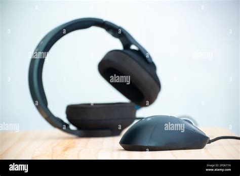 Headphone And The Mouse In A Wooden Computer Table Mouse In Focus As Headset Blurred Behind