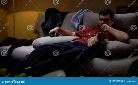 Young Lazy Single Male Watching Tv Lying On Couch After Work And