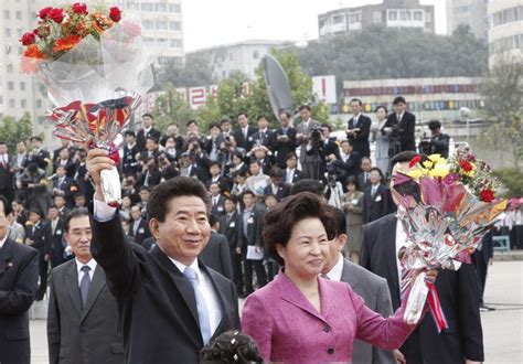 [노무현사료관] [북측 공식환영식에서 꽃다발을 들어보이며 인사하는 노무현 대통령 내외]
