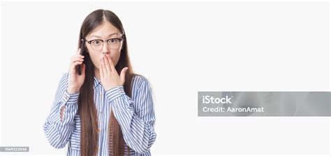 침묵 비밀 개념에에서 무서 워 하는 실수 두려움의 표현에 대 한 수치와 충격 손으로 전화 커버에 말하기 격리 된 배경 위에 젊은 중국 여자 놀라움에 대한 스톡 사진 및 기타