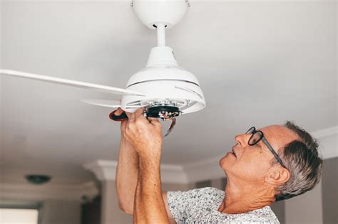 성숙한 경험 많은 전기 기술자가 계단에서 집 천장에 패들 선풍기를 설치하는 모습 Diy에 대한 스톡 사진 및 기타 이미지