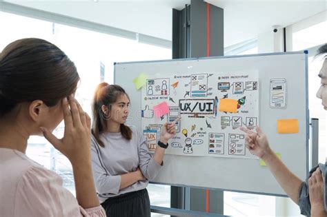 Group Of Asian Ux Developer And Ui Designer Serious Brainstorming About Mobile App Interface On