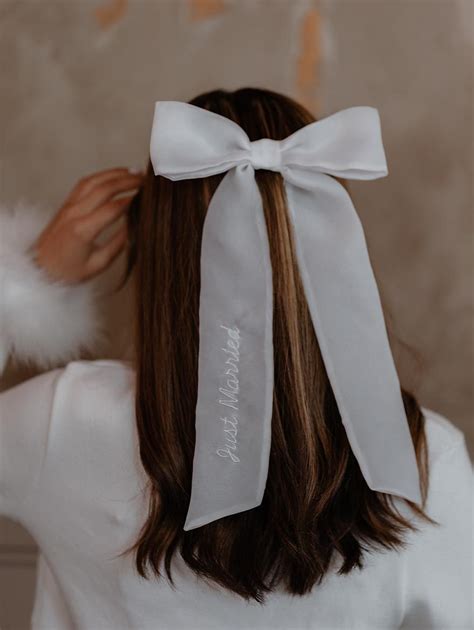 The Back Of A Womans Head With A White Bow And Name On It
