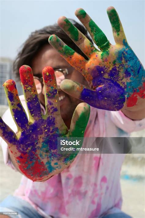 그림에 힌두교 인도 남자 웅 크 리고 페인트 전원이 덮인 손바닥에서 색상의 홀리 축제 페인트 싸움 사진 가리기에 대한 스톡 사진