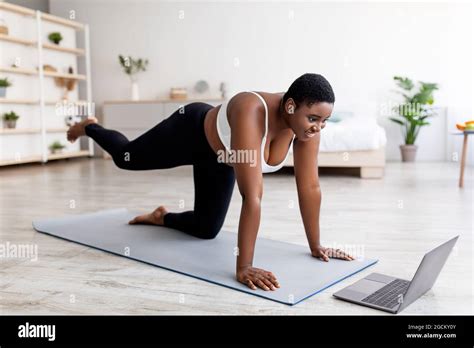 Plump Afro Woman Working Out Butt Muscles Near Laptop Following Video