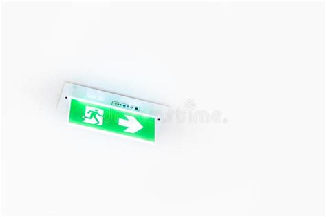 White Neon Sign Depicting A Fire Exit With Green Background Hangs From
