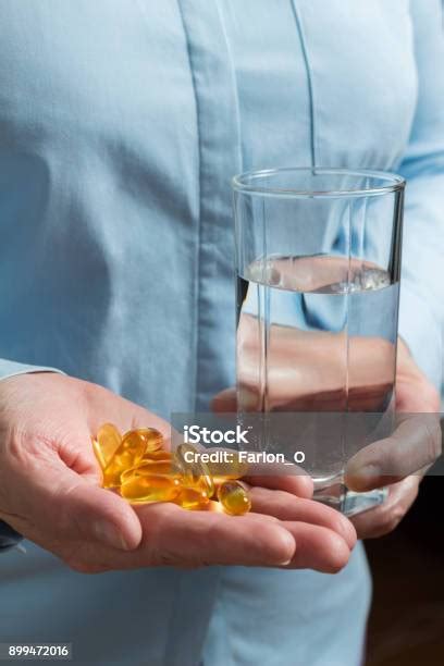 오메가 3 생선 기름 건강의 노란 약 캡슐 보충 반면에 물으로 여자 팜 손과 유리에서 약 개념에 대한 스톡 사진 및 기타 이미지 Istock