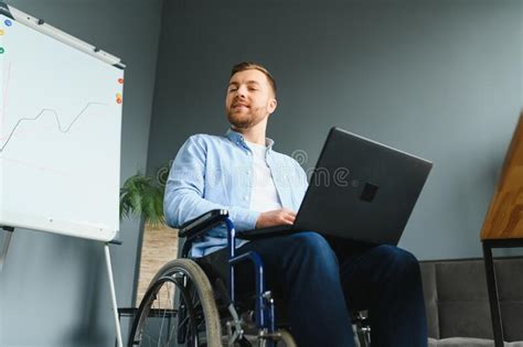 disabled person in the wheelchair works in the office at the computer