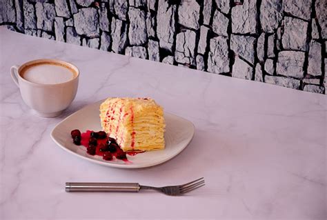 거품이 있는 신선한 카푸치노의 흰색 세라믹 컵 퍼프 케이크와 체리 시럽 포크가 있는 접시가 대리석 테이블에 있습니다 갈색에 대한 스톡 사진 및 기타 이미지 Istock