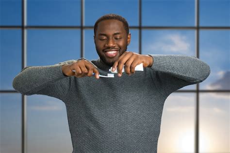Hombre Negro Aplicando Pasta De Dientes En Un Cepillo De Dientes