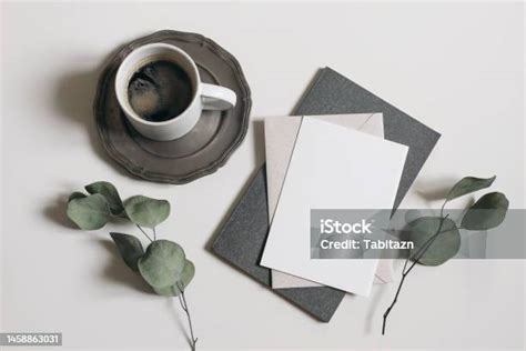 무디 아침 정물 문구류 빈 인사말 카드 초대장 모형 마른 유칼립투스 나뭇가지 회색 일기 은색 접시에 커피 한잔 흰색 테이블 배경 플랫 레이 평면도 봉투에 대한 스톡 사진 및