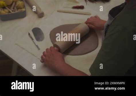 Girl Is Using A Wooden Stick To Roll Out A Flat Sheet Of Clay 4k Video Preparing Clay For