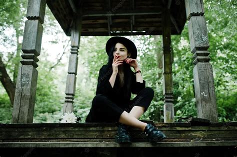 خرید و قیمت دختر سیگاری شهوانی با لب های قرمز مشکی و کلاه گوت زن دراماتیک در حال کشیدن سیگار