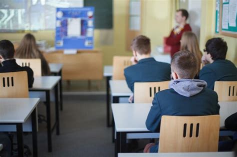 Premium Photo Rear View Of Students Sitting In Classroom