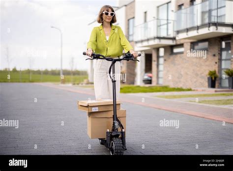 Woman Driving Electric Scooter With Cardboard Packages Stock Photo Alamy
