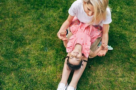 녹색 잔디에 앉아 어머니 야외와 함께 노는 행복 한 아이의 위에서 보기 행복 한 여자와 그녀의 아이는 공원에서 함께 연주 행복 한 사랑의 감정 행복 한 어머니의 날입니다