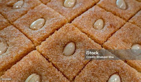 아랍 요리 전통 아랍어 디저트 바스부사 이집트 오리엔탈 세몰리나 케이크에 황금빛 바삭한 아몬드를 얹었습니다 차 꿀 시럽 신선한 맛있는 크림과 함께 제공됩니다 0명에 대한