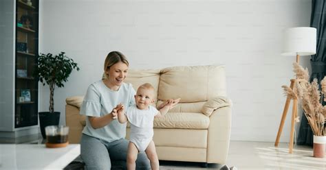 어린 행복한 어머니는 어린 아들이 집에서 첫 걸음을 내딛는 것을 돕고 있습니다 공간을 복사합니다 사진 Unsplash의 세르비아 이미지