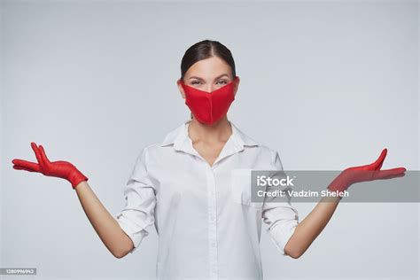빨간 장갑과 얼굴 마스크를 매력적인 소녀 코로나바이러스 비드 19의 예방 개념 흰색 배경에 스튜디오에서 사진 세션 30 34세에