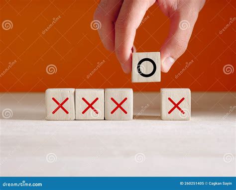 Hand Puts The Wooden Cube With O Symbol Next To The Cubes With X