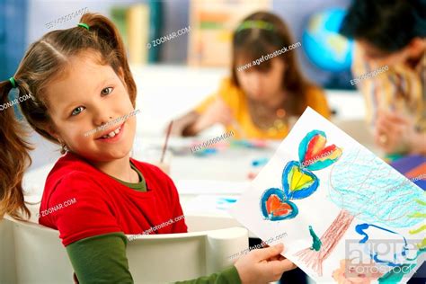 Portrait Of Elementary Age Schoolgirl Showing Colorful Paining To