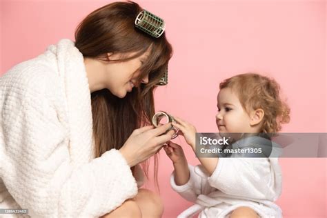 젊은 아름다운 행복한 여자와 작은 아이 어머니와 딸은 분홍색 배경에 고립 된 재미를 목욕 가운을 입고 어머니의 날 가족 어린 시절 2 3 살에 대한 스톡 사진 및 기타
