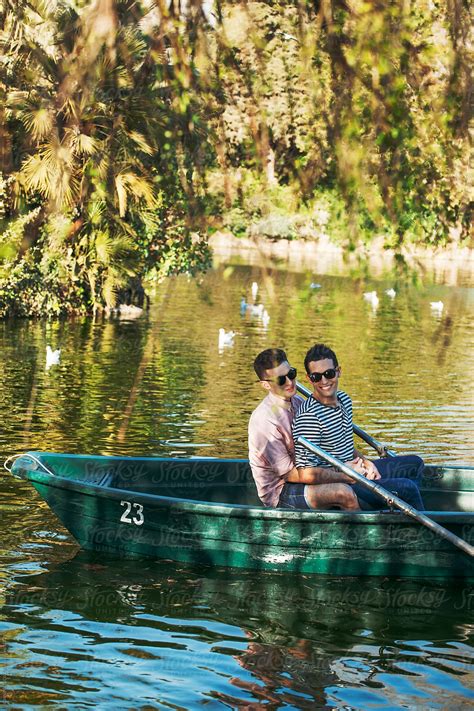 Smiling Gay Couple Relaxing On Boat At Lake By Stocksy Contributor
