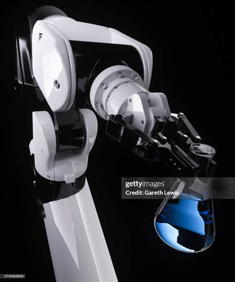 Automated Robot Arm Holding A Glass Of Blue Liquid In A Science