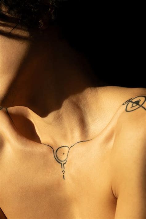 개인적 표현 교활한 그림자 독창성 독특한 디자인 따뜻한 음색 라인 아트 문신 문자 미니멀리스트 바디 아트 빛과 그림자 섬세한 소프트 포커스 쇄골